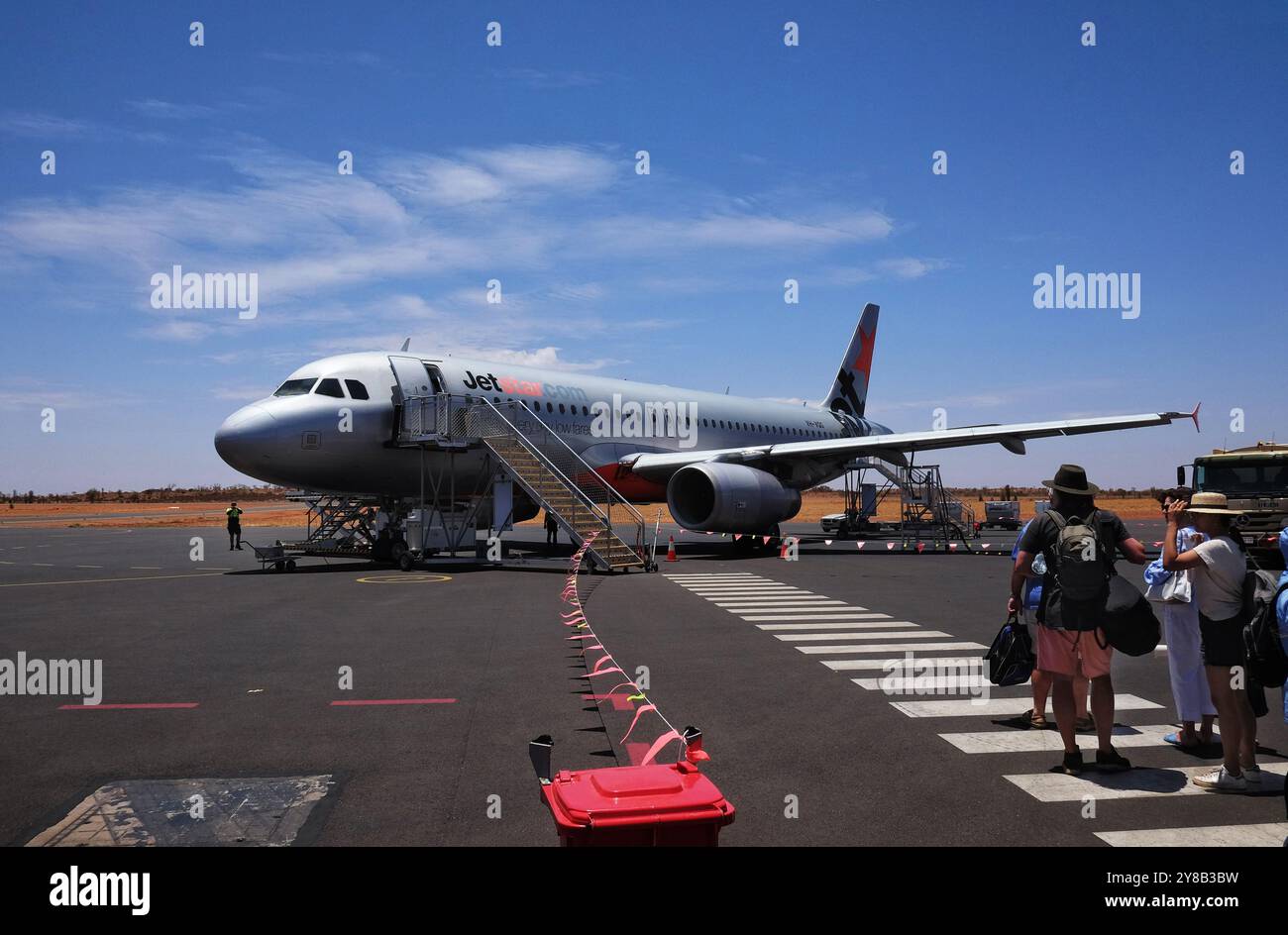 A Jetstar Airbus aircraft boarding passengers walking across the tarmac ...