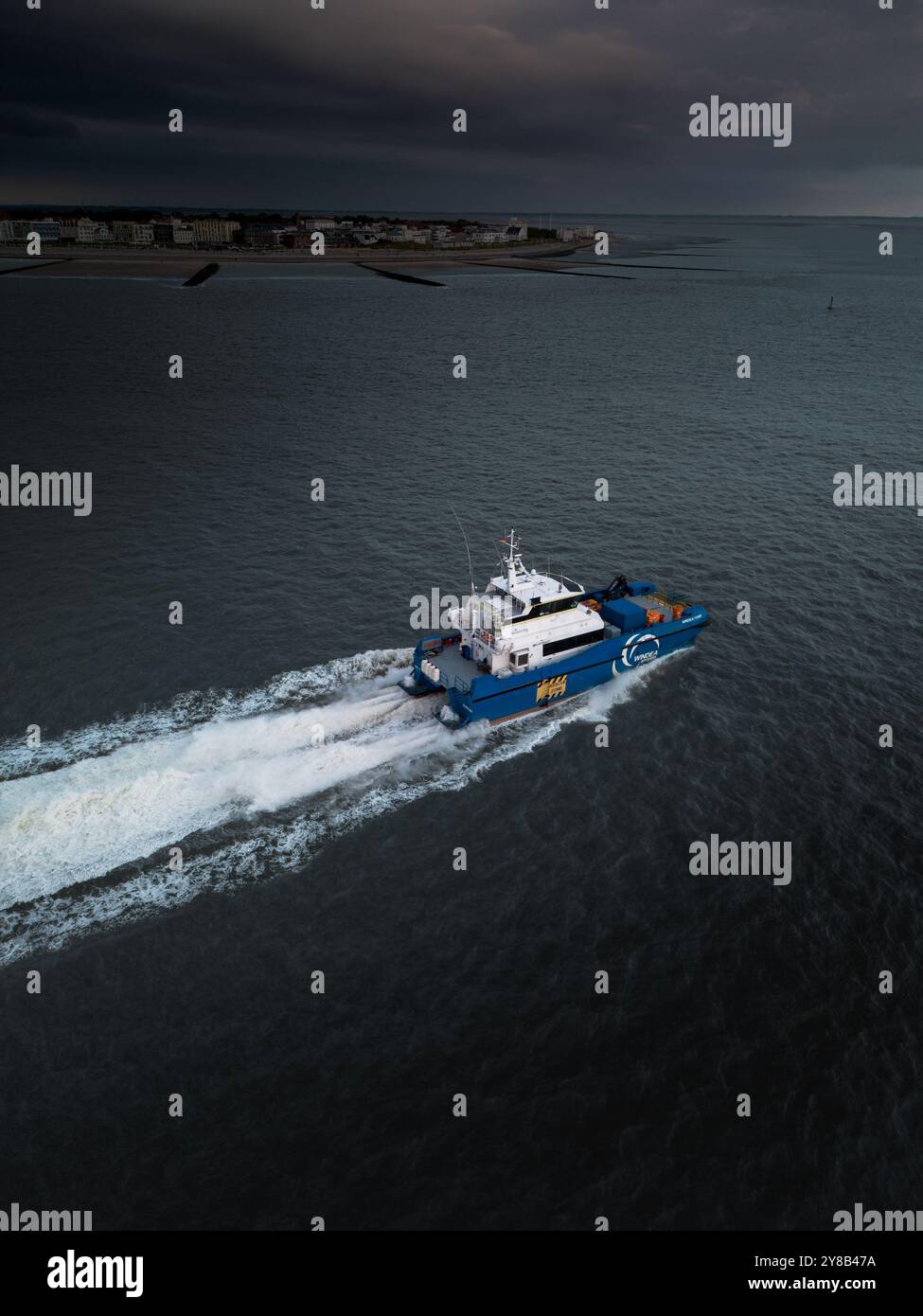 Aerial view of a blue and white offshore catamaran at high speed at the ...