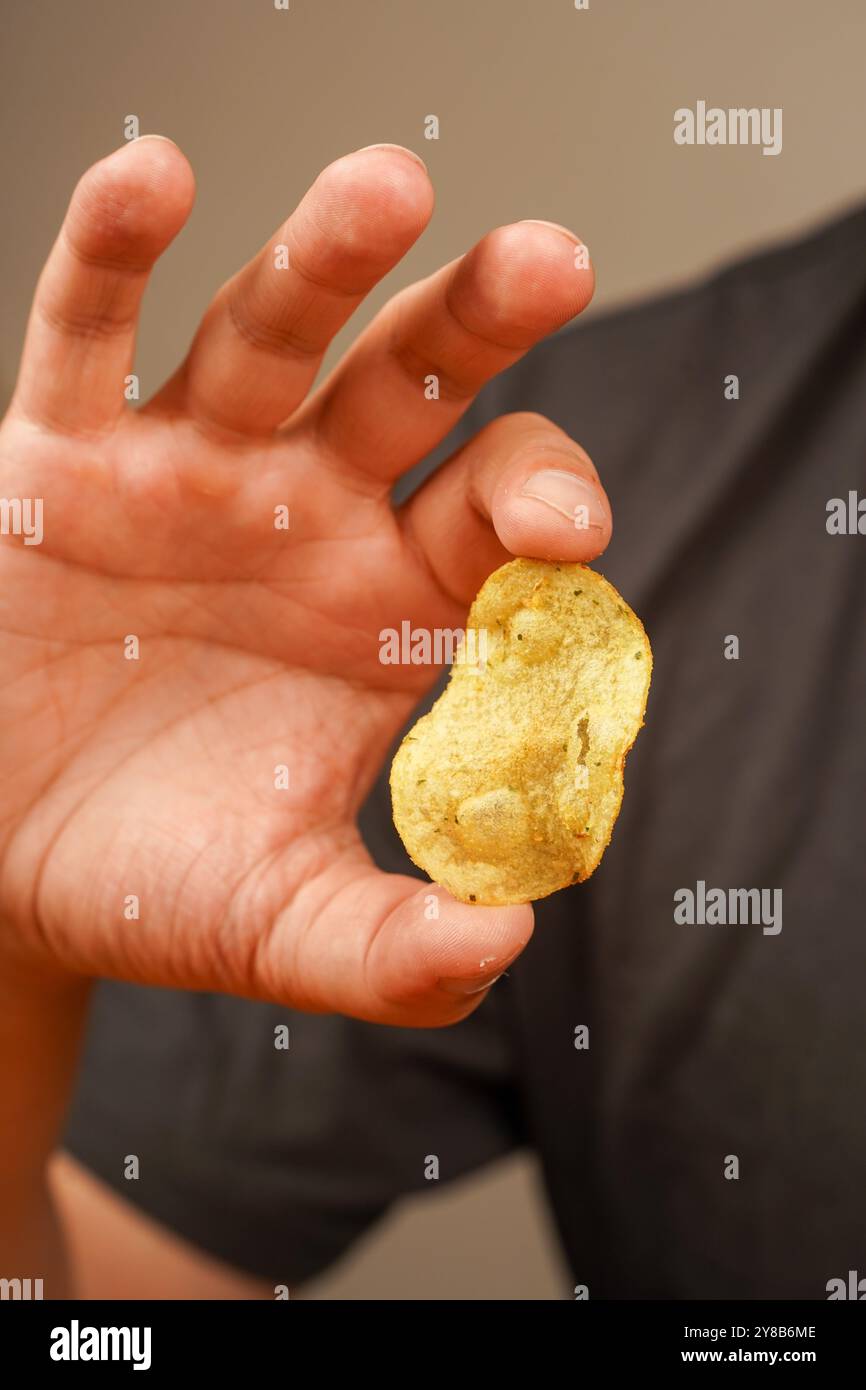 Hands hold potato chip. Calories. Obesity. American food. Okay sign ...
