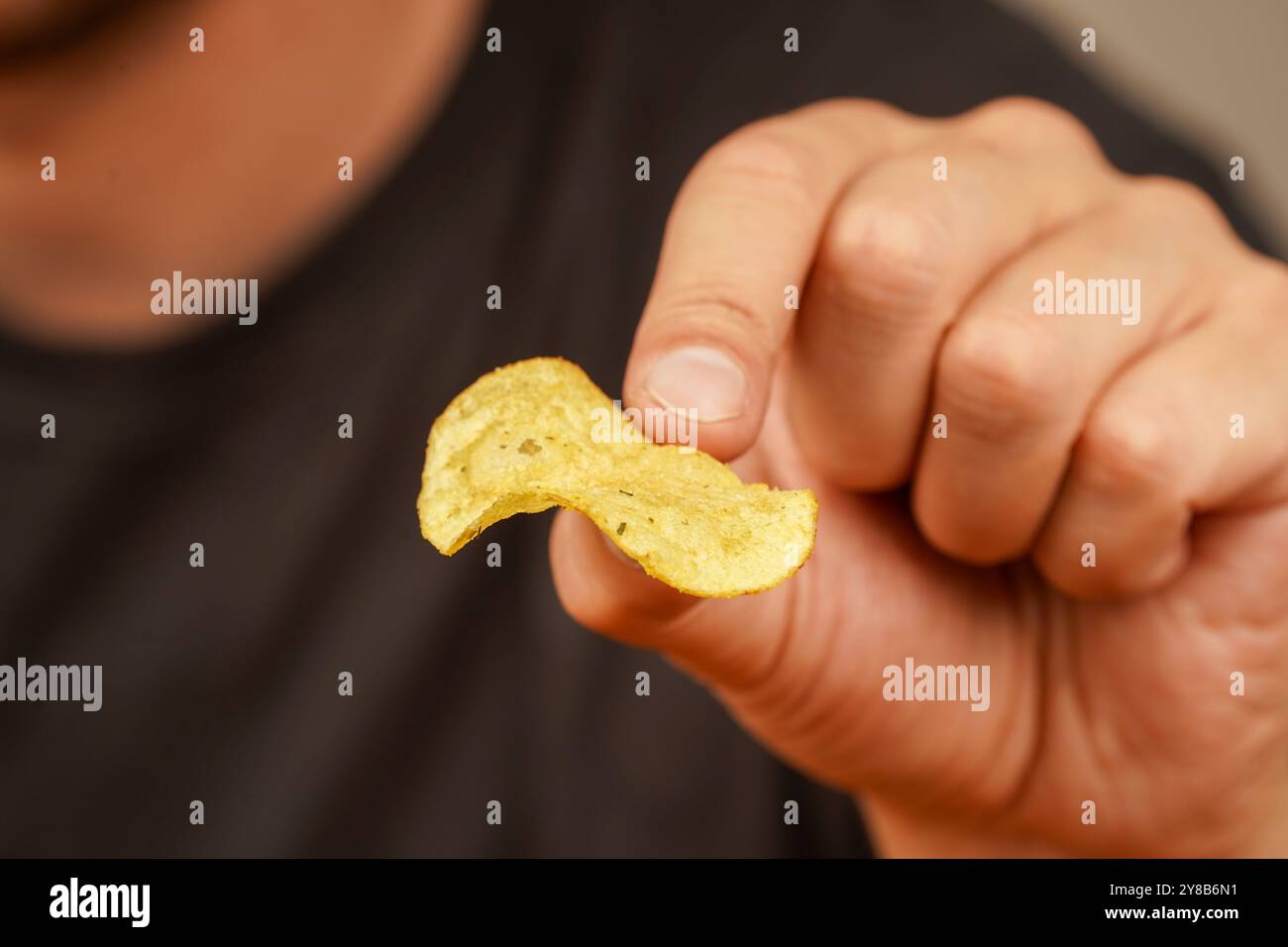 Hand holding potato chip closeup. Calories. Obesity. American food ...
