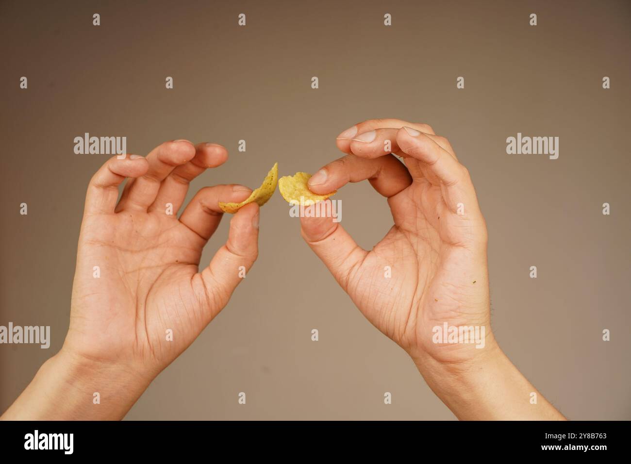 Hands hold potato chip. Calories. Obesity. American food. Unhealthy ...