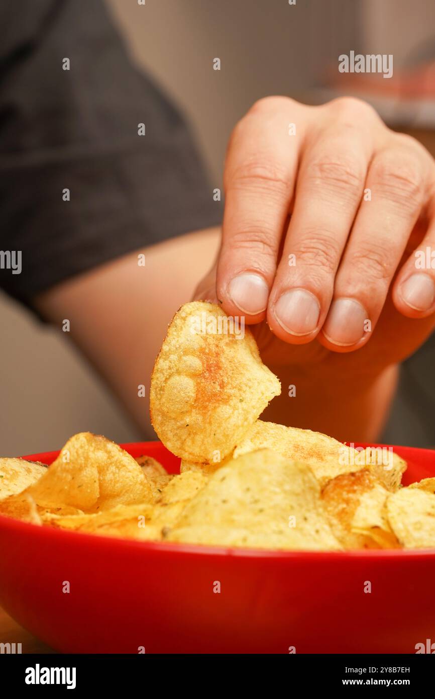 Man eating potato chips. Hands holds potato chips. A view of a hand ...