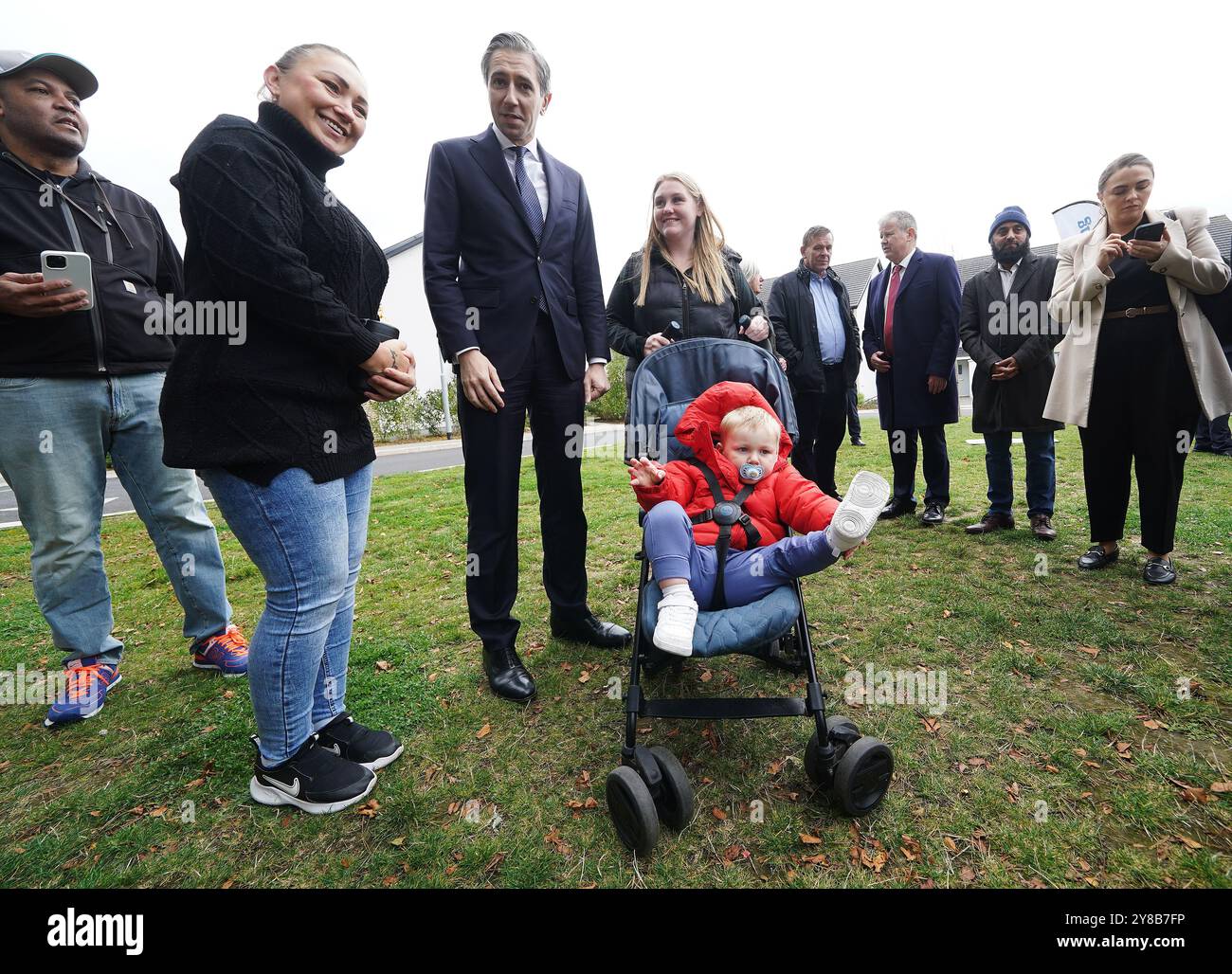 Taoiseach Simon Harris with residents Rebecca Lunders (centre), her two ...