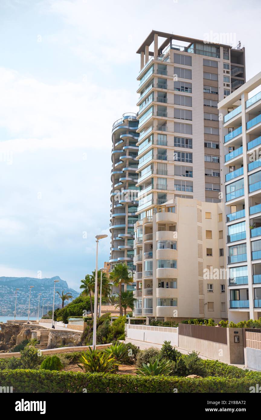 Contemporary high-rise beachfront apartments with glass balconies, lush ...