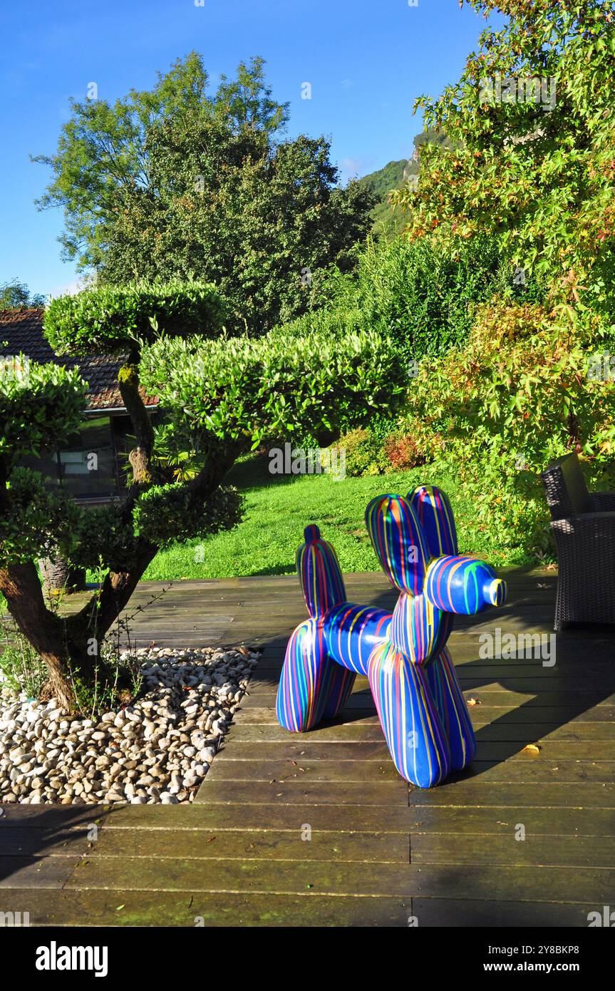 Colorful clay dog by the pool with cut olive tree cloud cut Stock Photo - Alamy