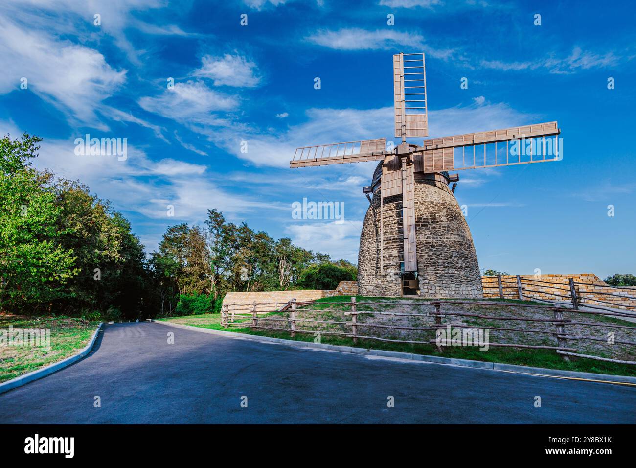 Stone windmill stands tall under a vibrant blue sky with scattered ...
