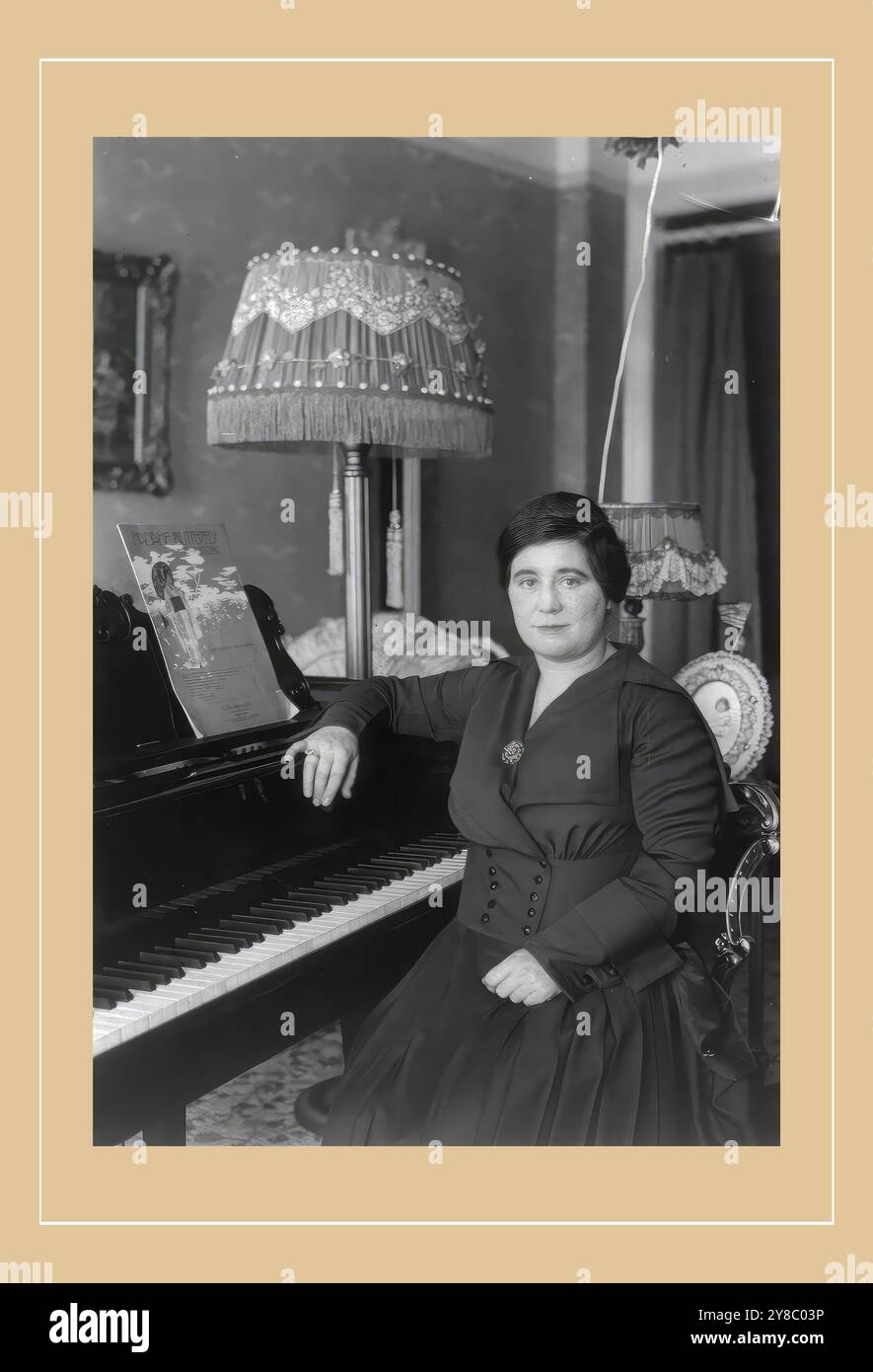 Amy Castles, three-quarters length portrait, seated at piano, facing ...