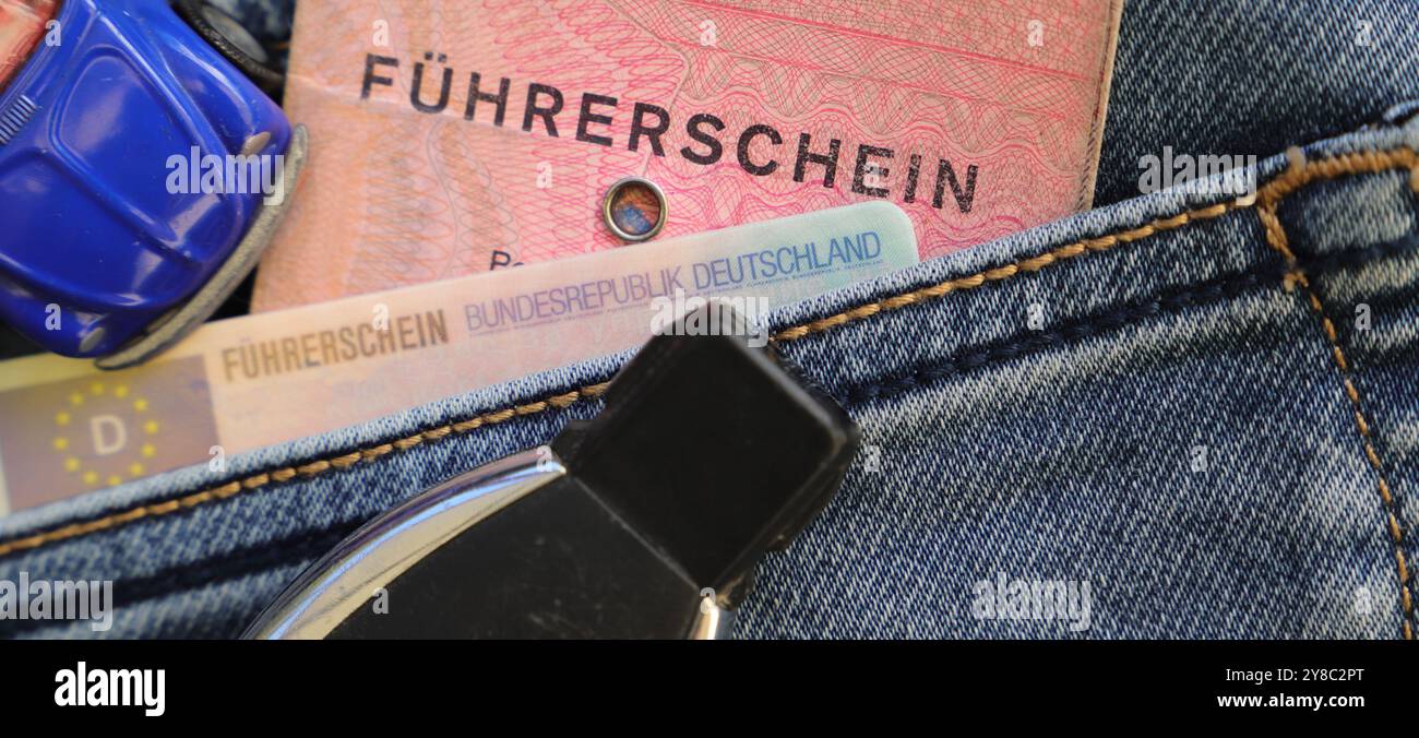 an old and a new German driving license in a trouser pocket and a car ...