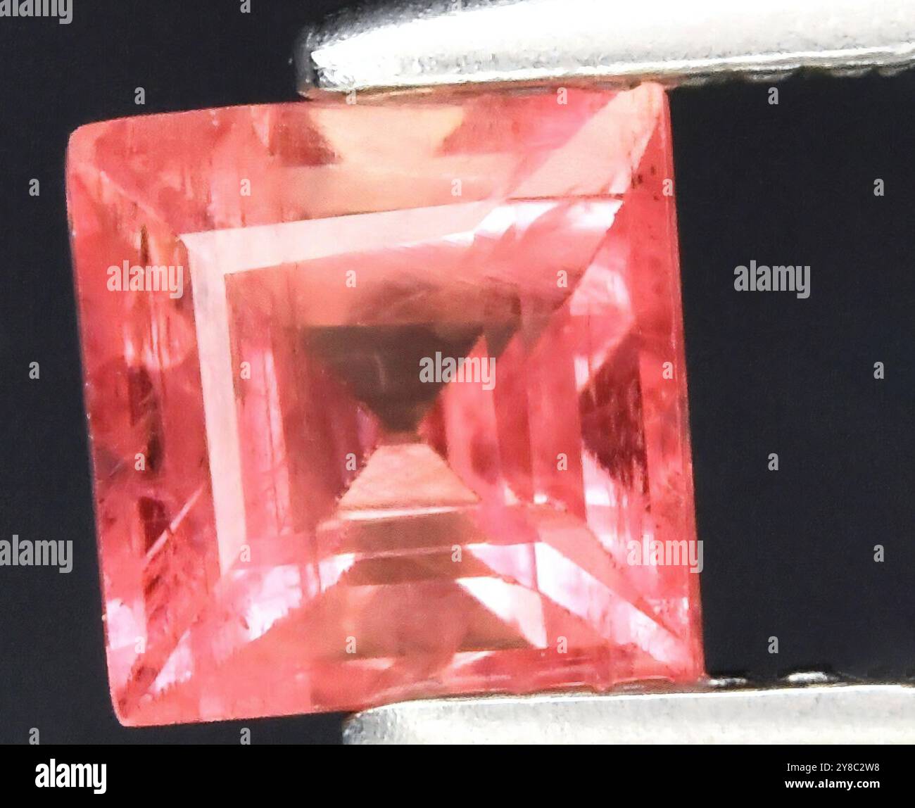 Radiant Pink Gemstone with Intricate Cut Set Against Black Background ...