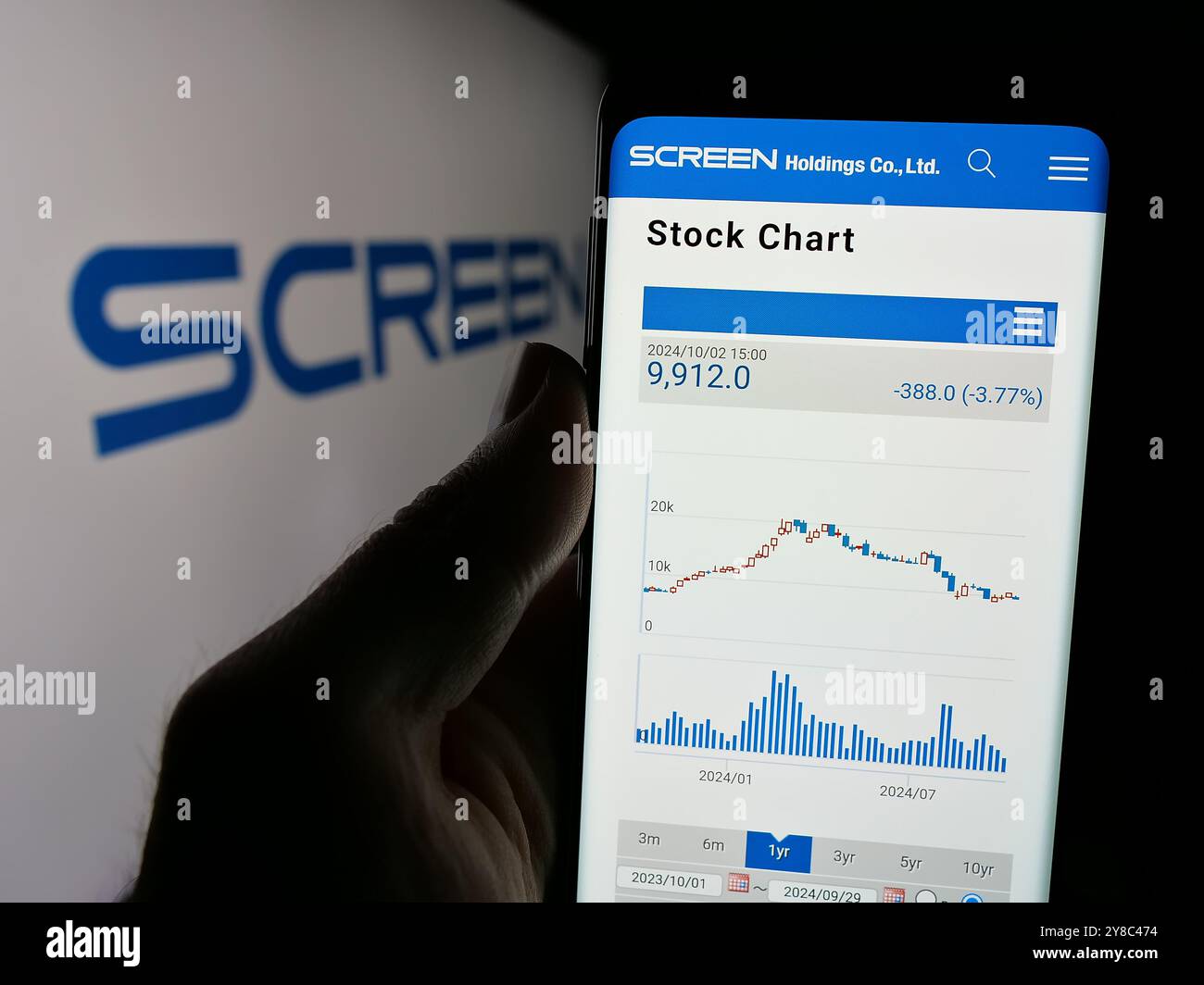 Person holding smartphone with webpage of Japanese company Dainippon ...