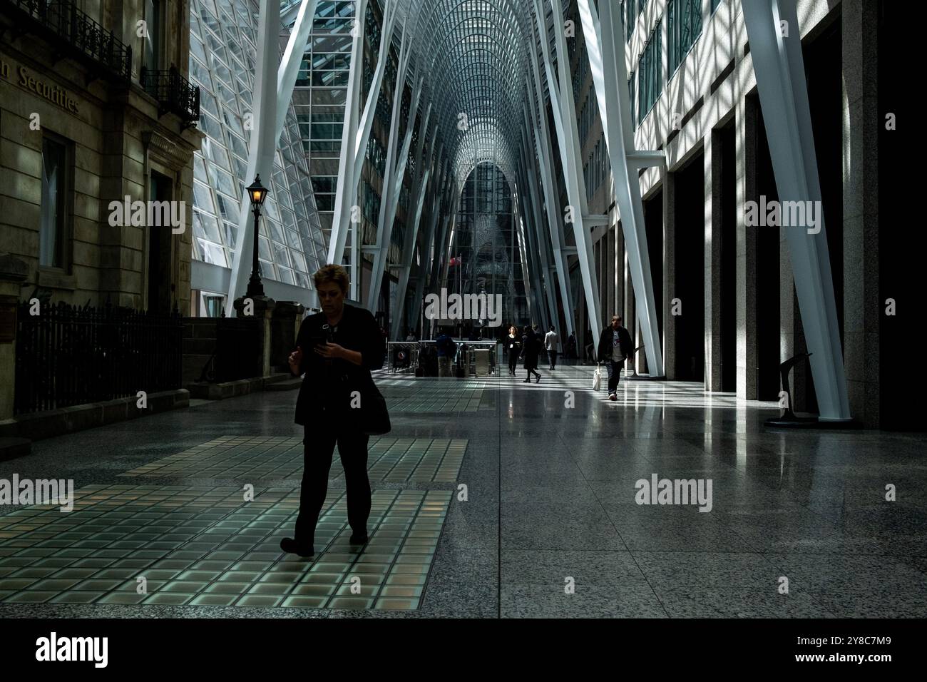 Worker passing through the Allen Lambert Galleria, an interior glass ...