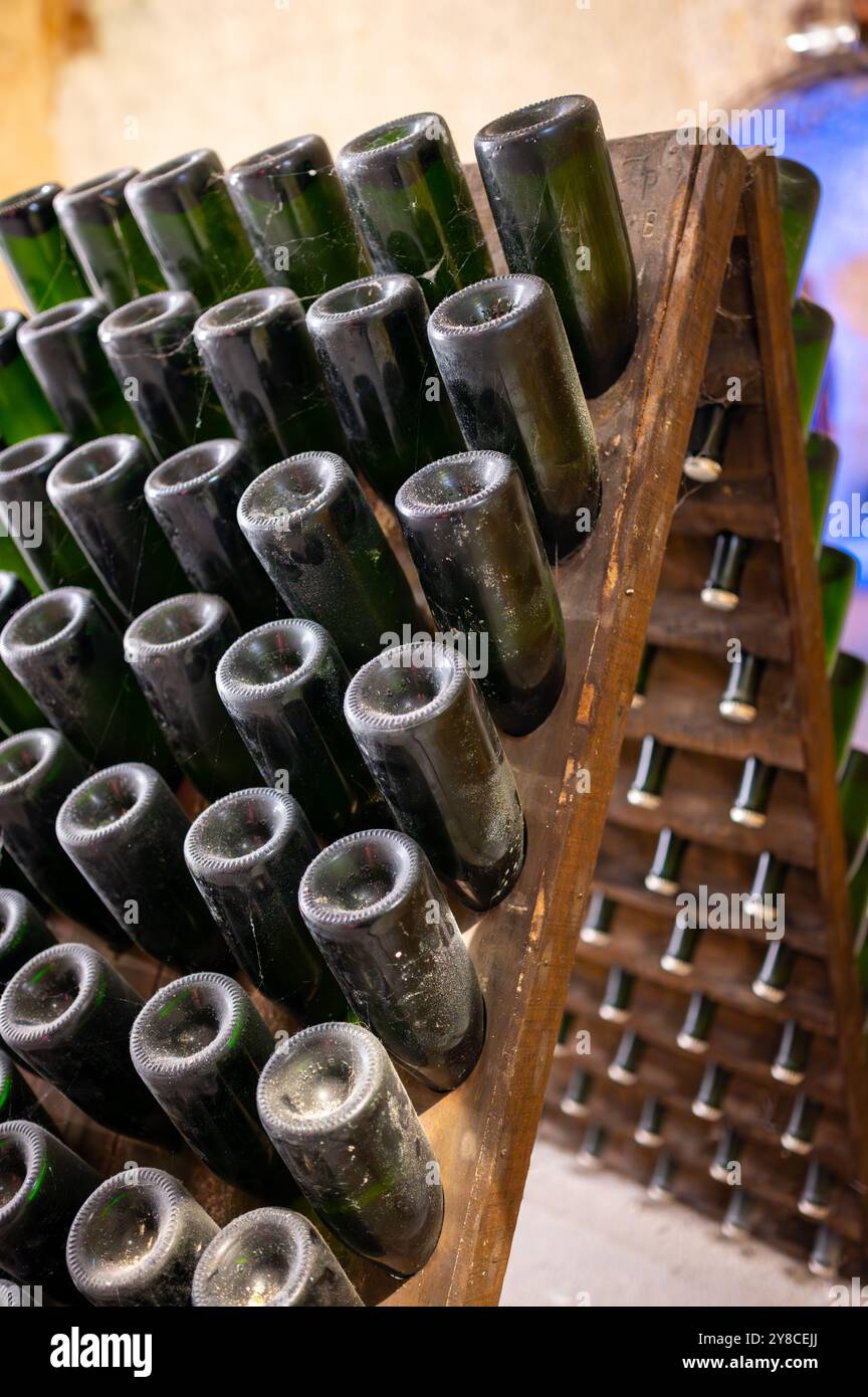 Champagne bottles on pupitre riddling racks in deep and long ...