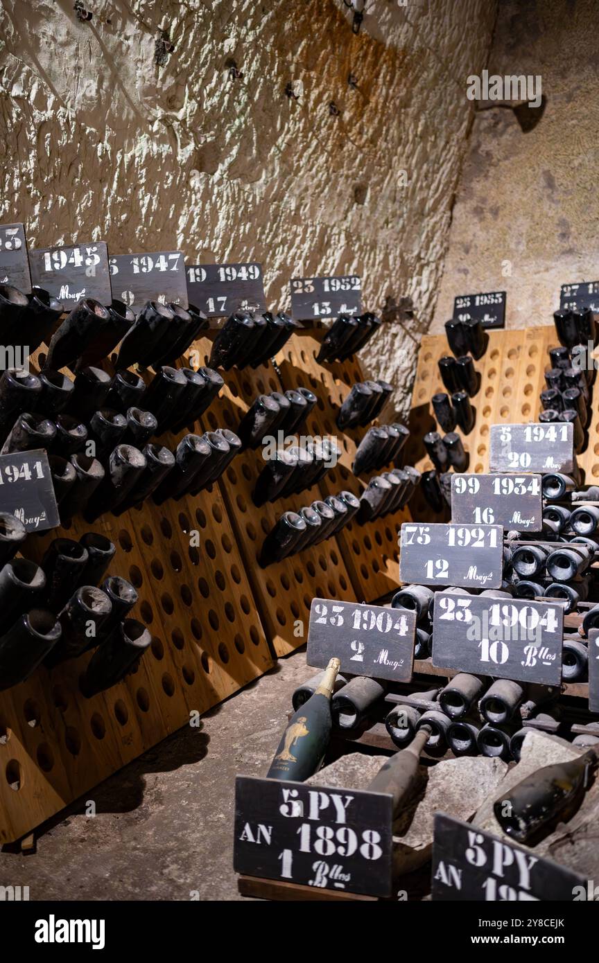 Champagne bottles on pupitre riddling racks in deep and long ...