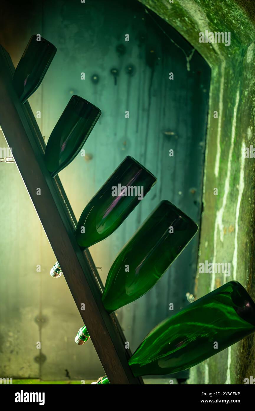 Champagne bottles on pupitre riddling racks in deep and long ...