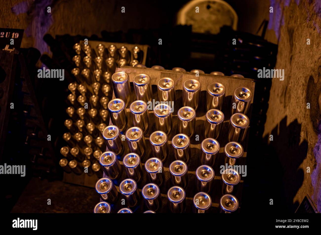 Champagne bottles on pupitre riddling racks in deep and long ...