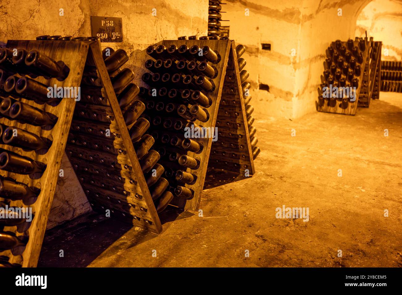 Champagne bottles on pupitre riddling racks in deep and long ...