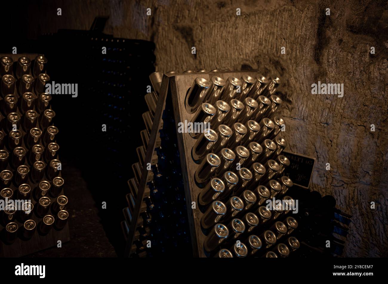 Champagne bottles on pupitre riddling racks in deep and long ...