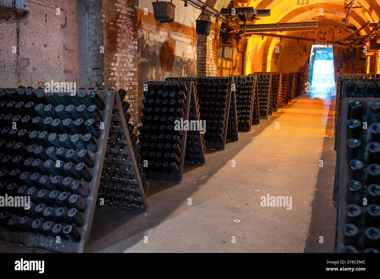 Champagne bottles on pupitre riddling racks in deep and long ...