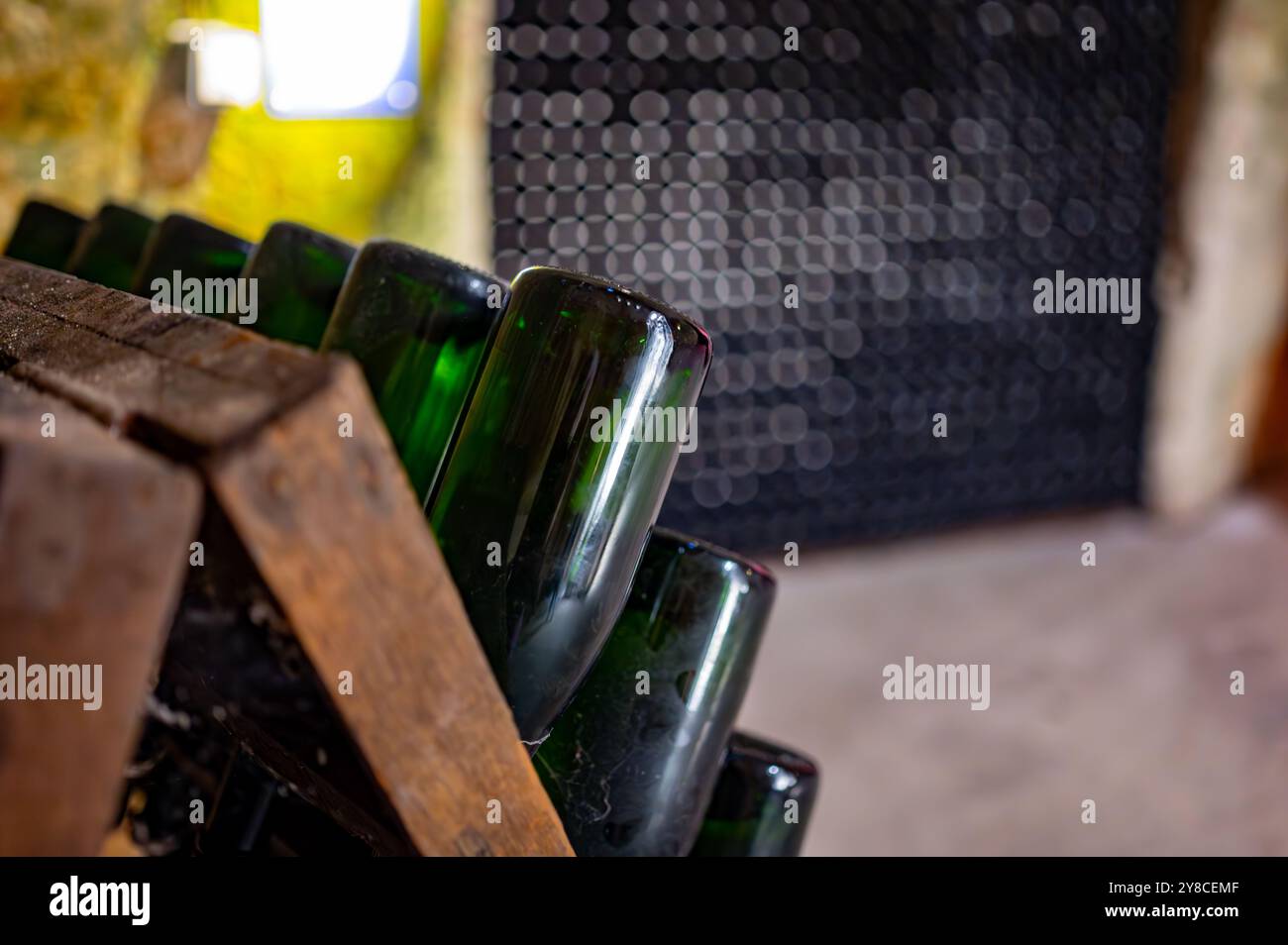 Champagne bottles on pupitre riddling racks in deep and long ...