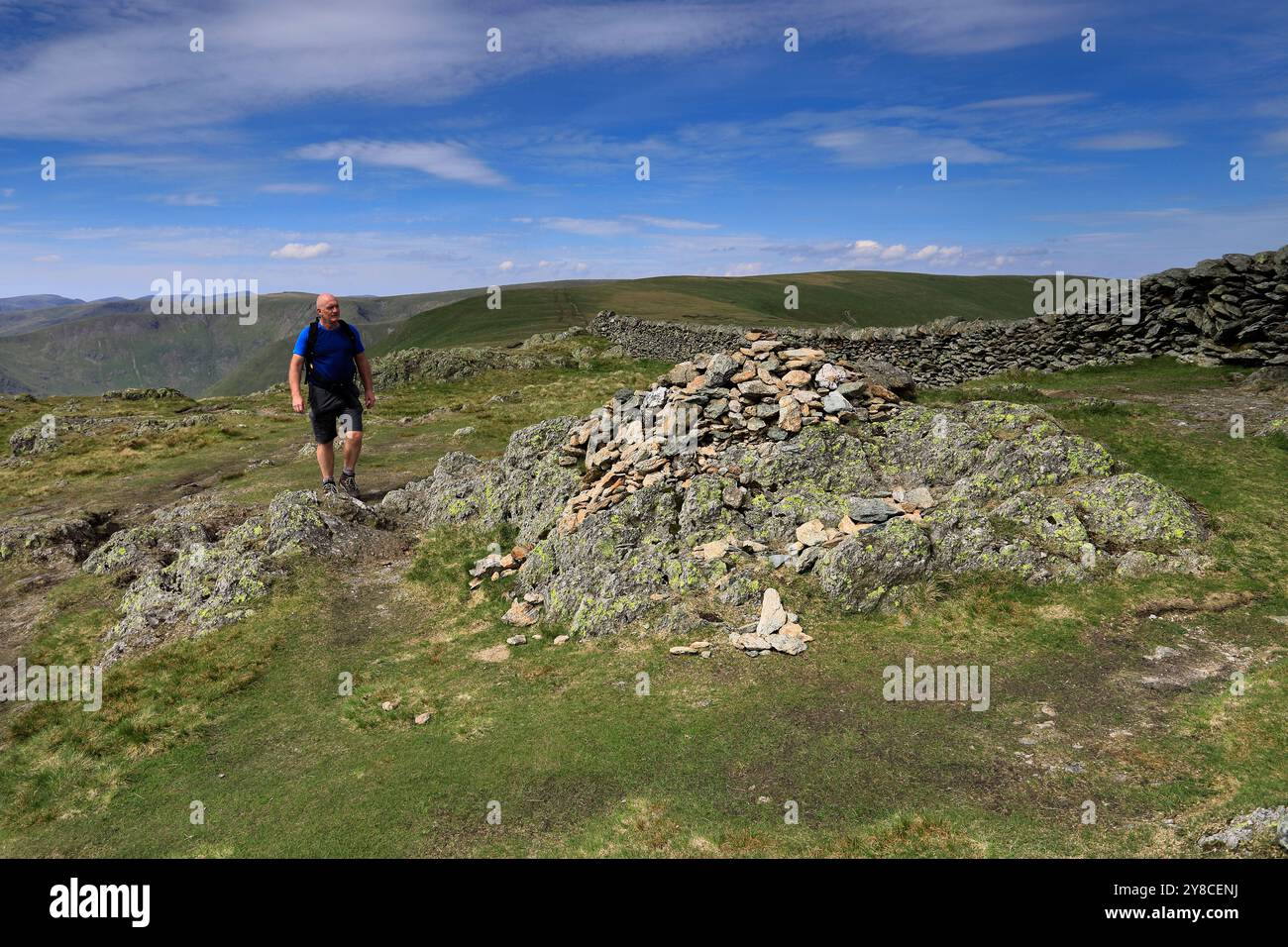 Walker at the Summit Cairn of Kentmere Pike fell, above the village of ...