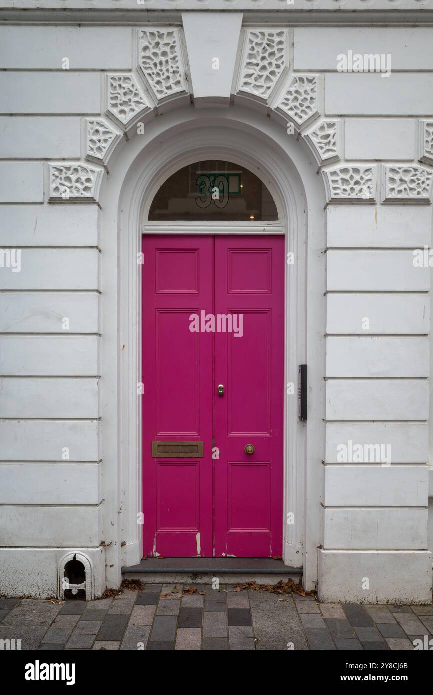 Pink panel front door with arch window above the door Stock Photo - Alamy