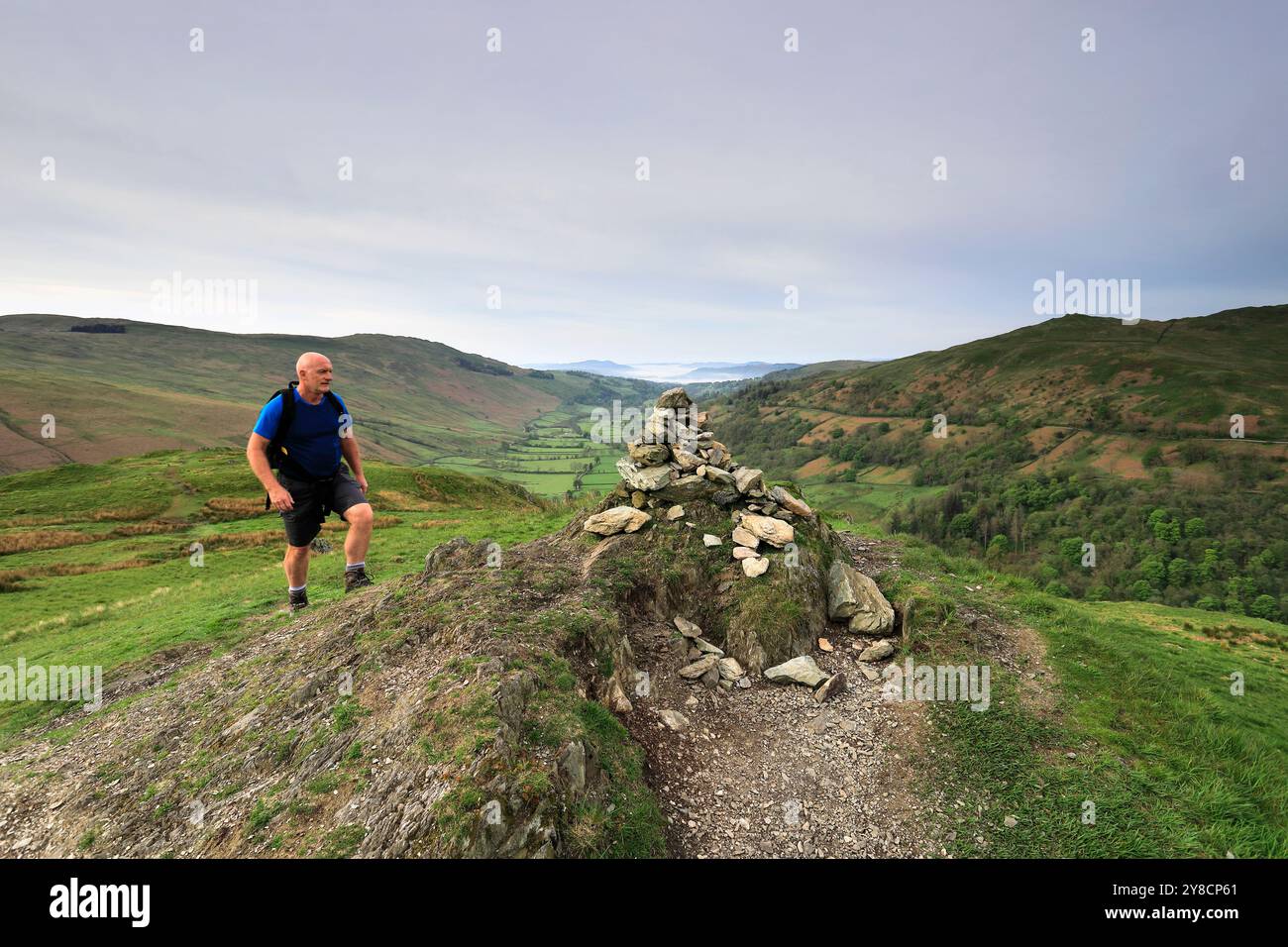 Walker at the Summit Cairn of Troutbeck tongue fell, Troutbeck valley ...