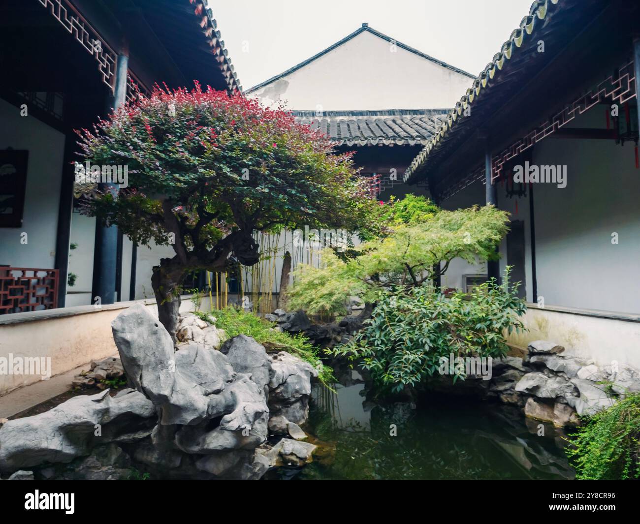 A tranquil traditional garden features vibrant trees and a peaceful ...