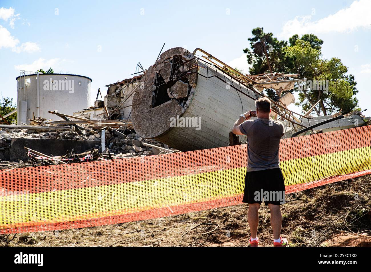 A man takes photos of a building that was destroyed by an Iranian ...