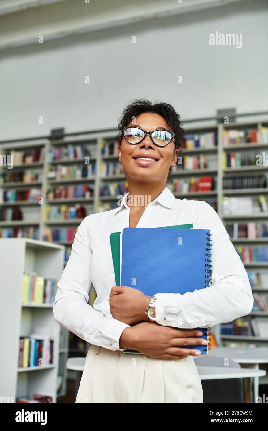 A passionate teacher holds colorful notebooks, inspiring learners in a ...