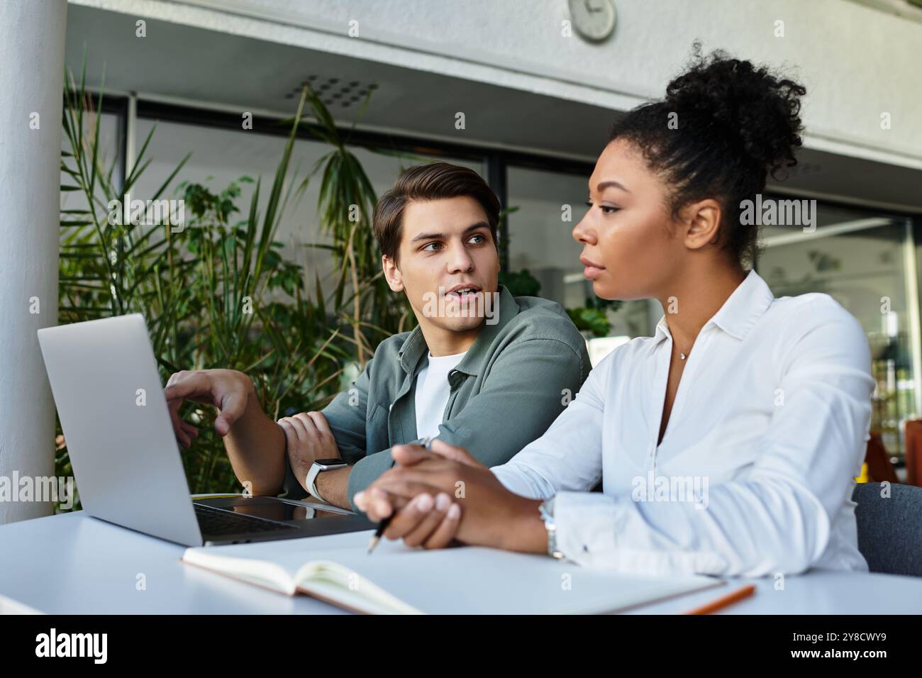 Student and his teacher are focused on their laptops while sharing ...