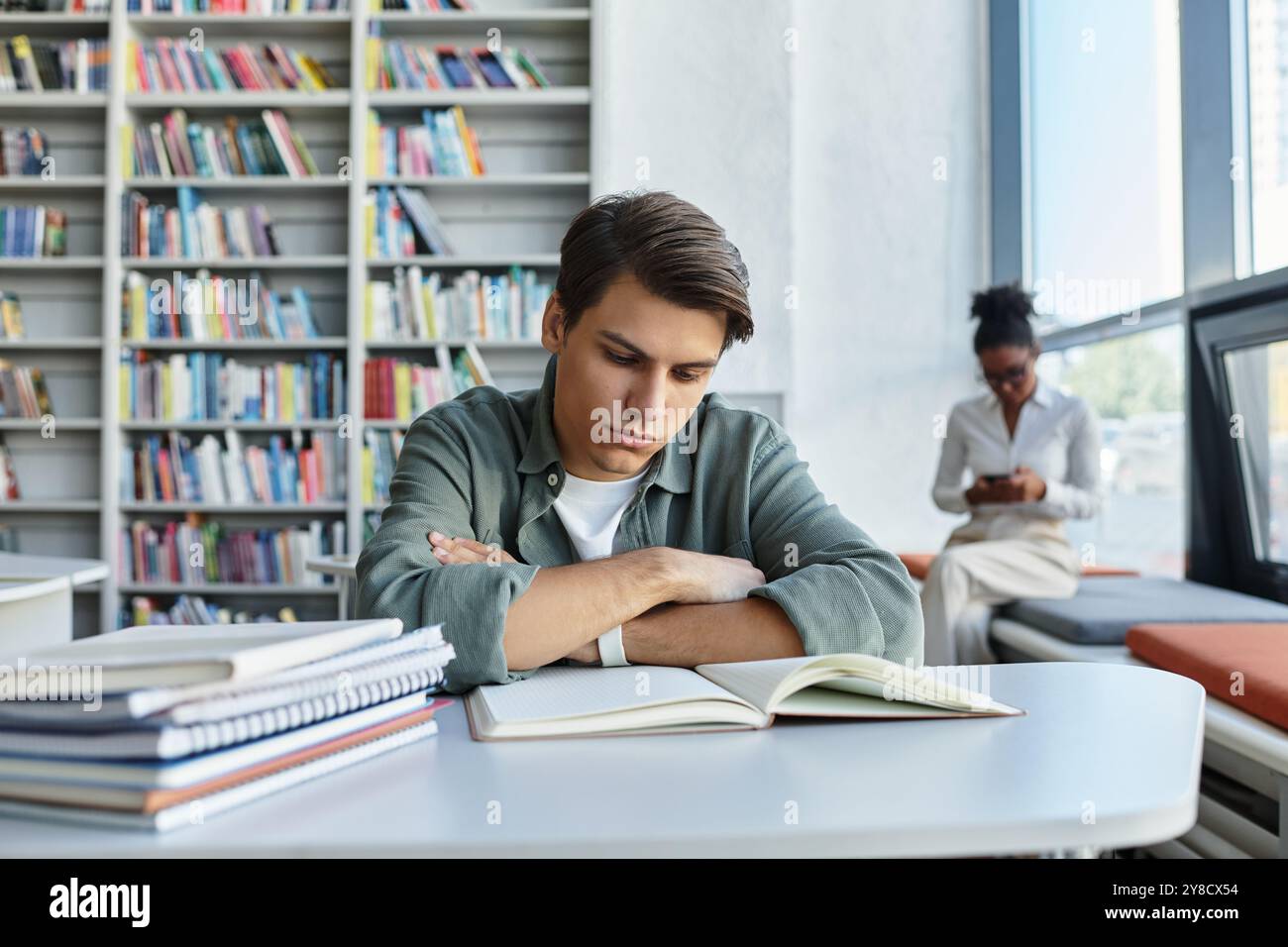A teacher working on backdrop and a young student immersed in reading ...