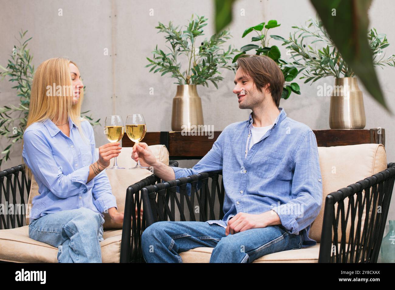 Happy young couple toasting and drinking alcoholic white wine in an ...