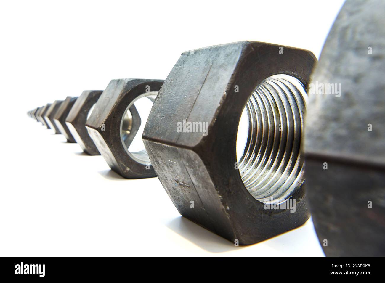 Row of threaded metal nuts on isolated white background Stock Photo - Alamy