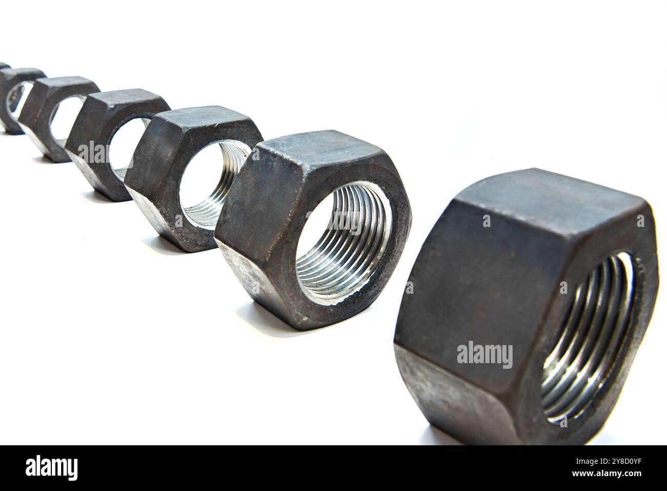 Row of threaded metal nuts on isolated white background Stock Photo - Alamy