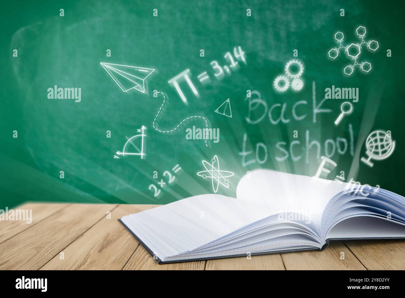 Green blackboard or chalkboard with open textbook from which they fly ...