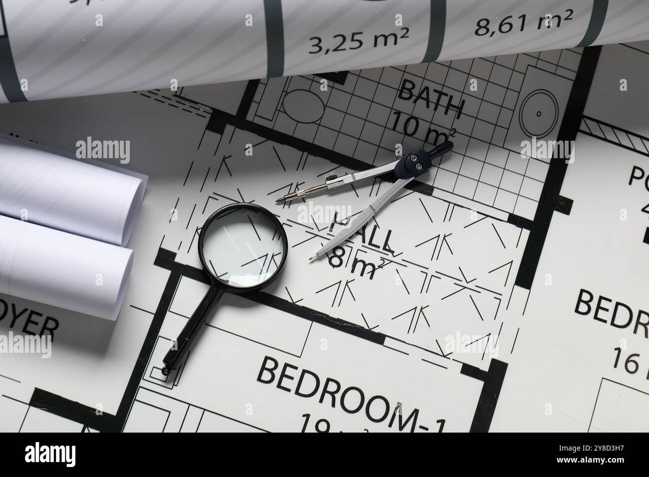 Dividers and magnifying glass on different architectural drawings, top ...