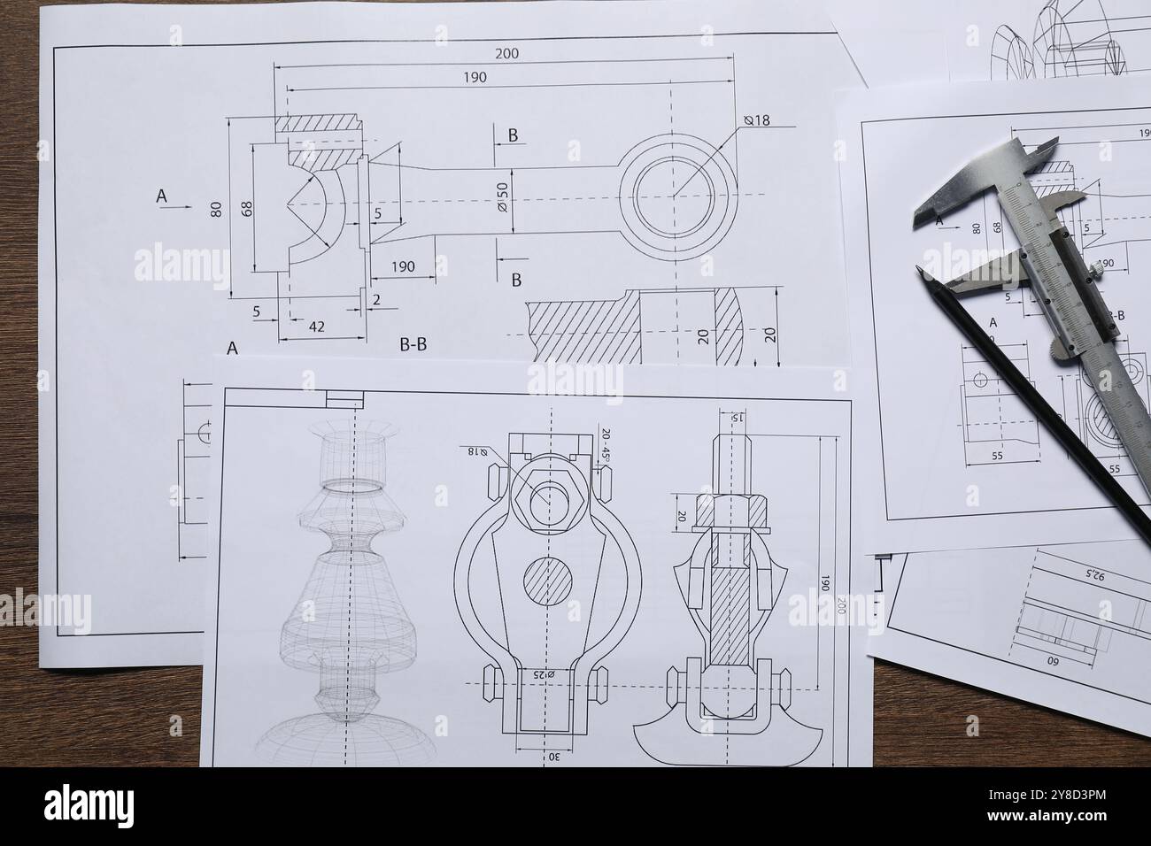 Different engineering drawings, vernier caliper and pencil on wooden ...