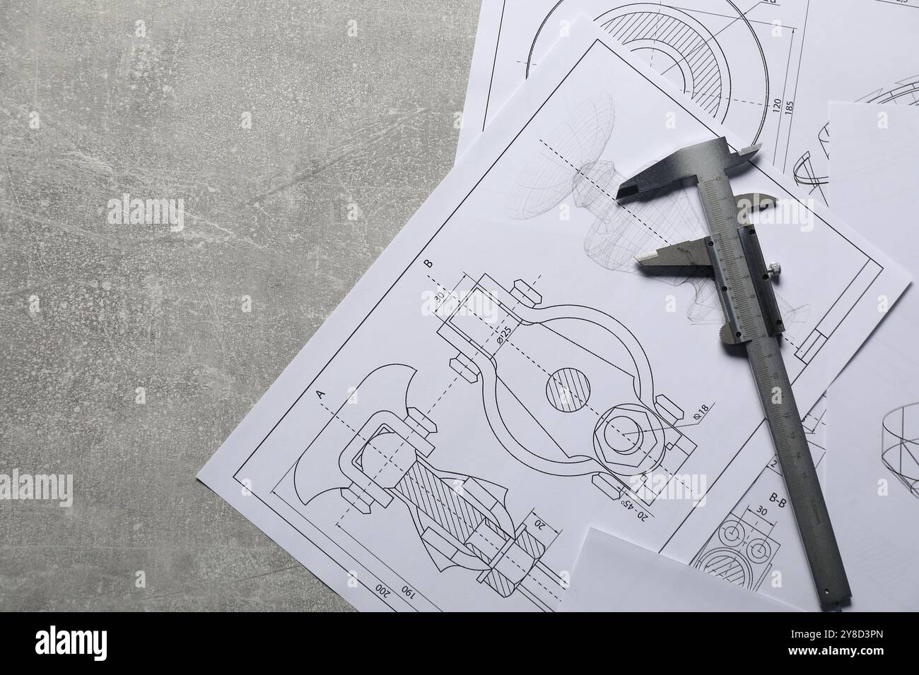Different engineering drawings and vernier caliper on gray textured ...