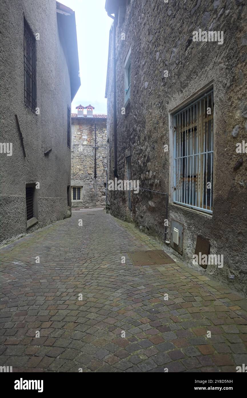 Dead end narrow alley between buildings with stone walls in a town ...