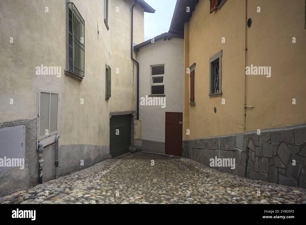 Narrow dead end alley between buildings that leads to a closed gate ...