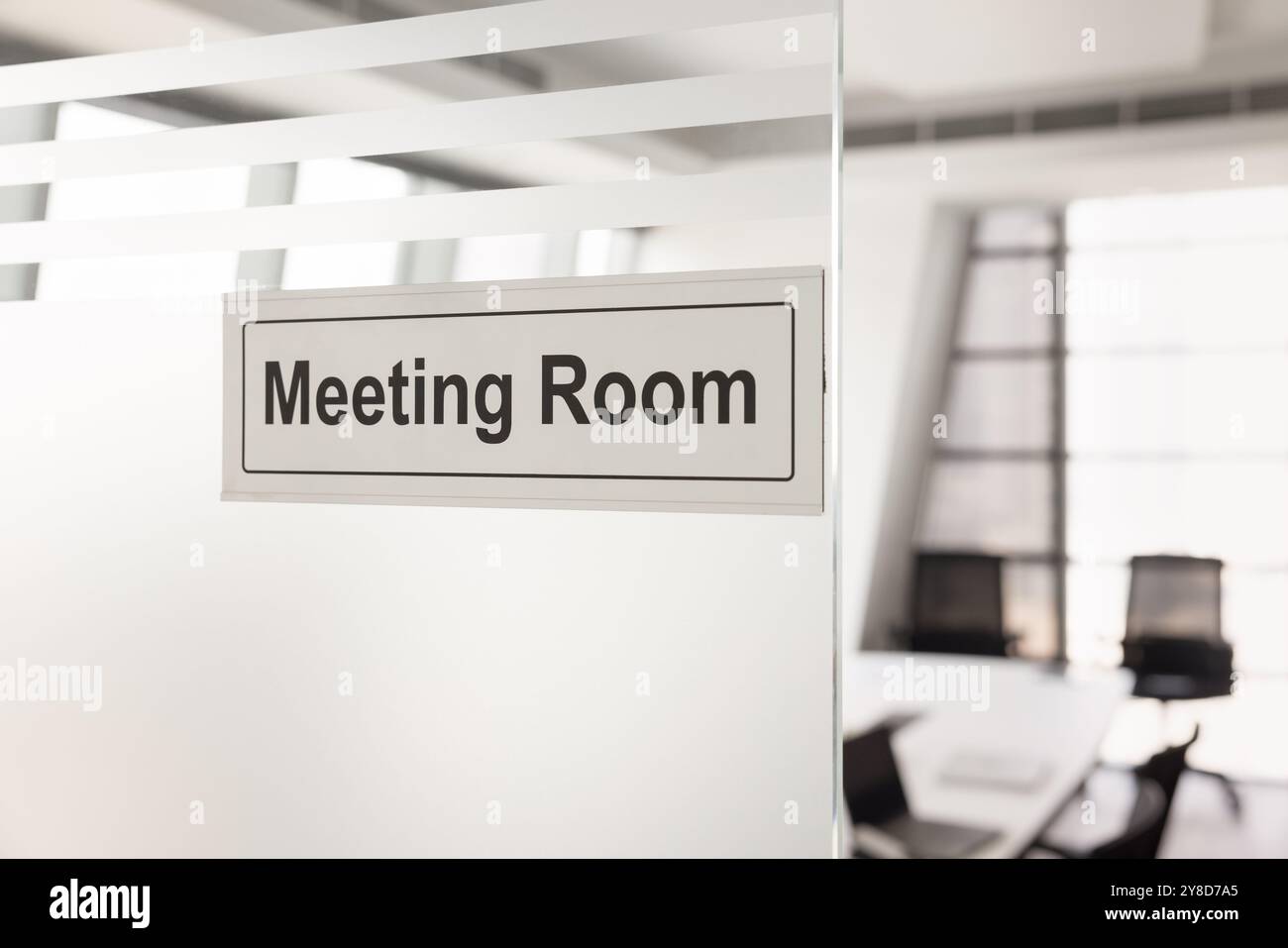 Meeting room sign on office glass wall with empty workspace Stock Photo ...