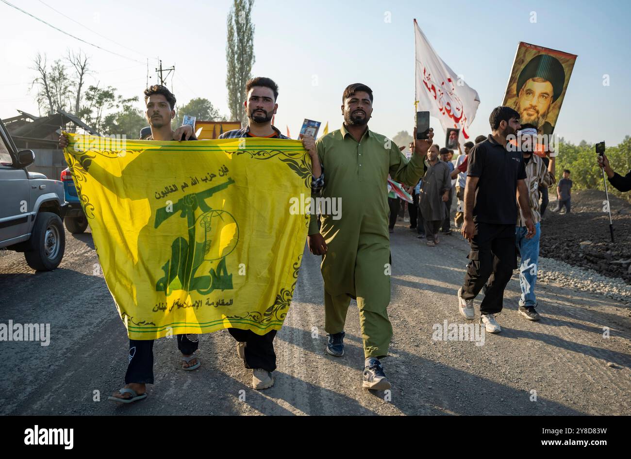 Kashmiri Shia Muslims walk with a flag of Hezbollah and Sayyed Hasan ...