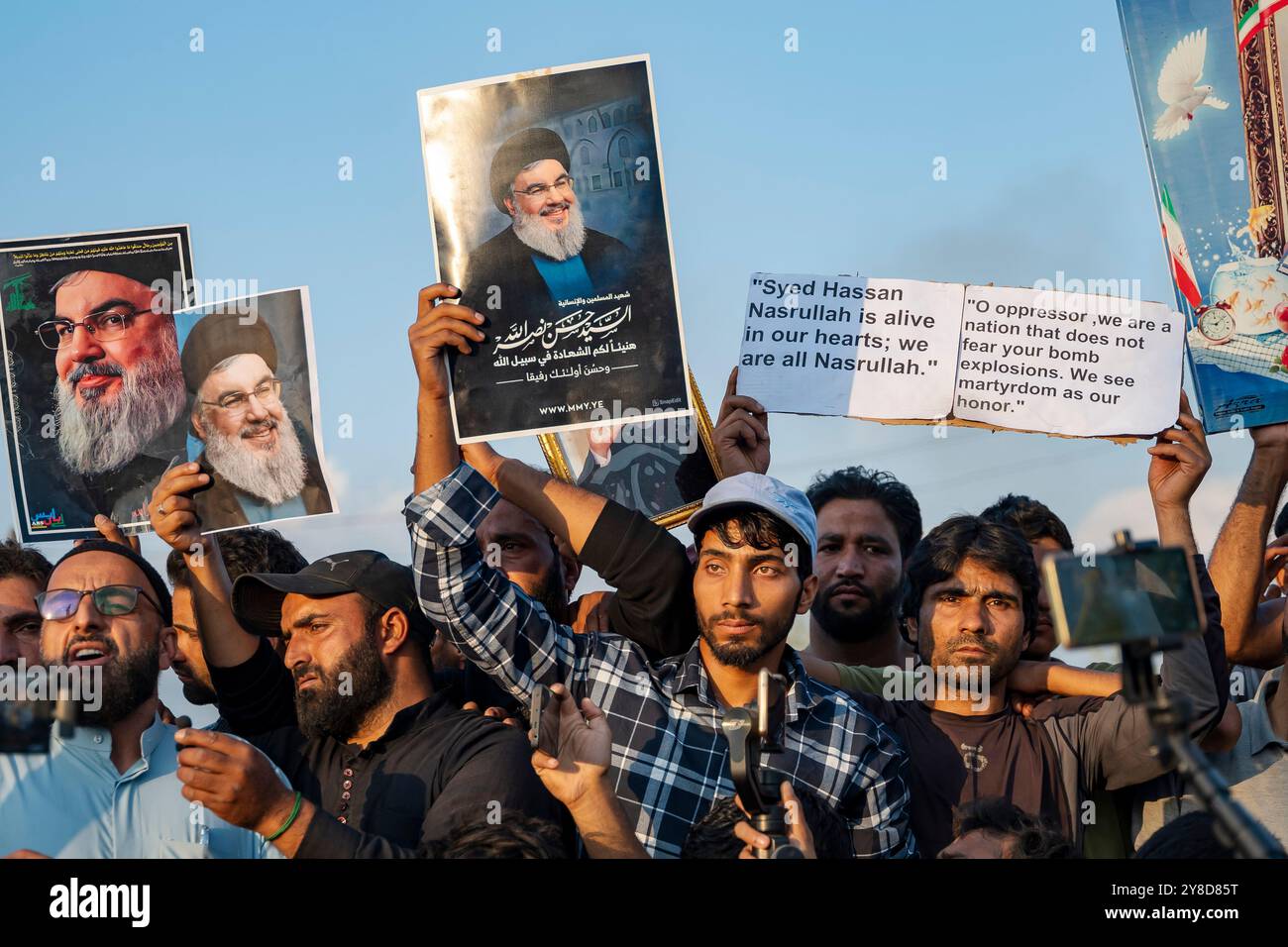 Kashmiri Shia Muslims listens to a religious speaker while holding ...