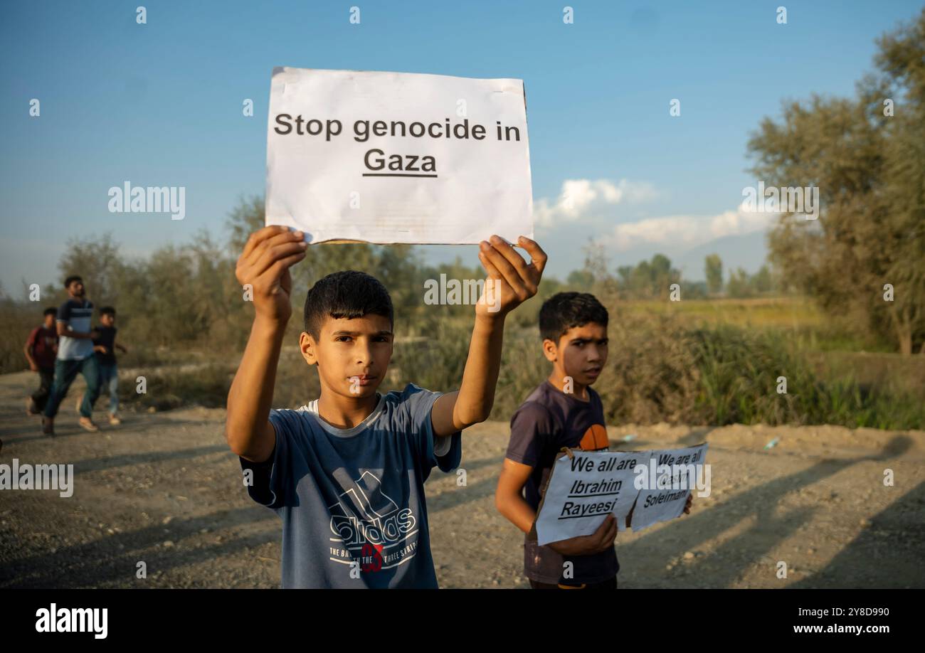 A Kashmiri Shia Muslim boy holds a placard that says "Stop Genocide in ...