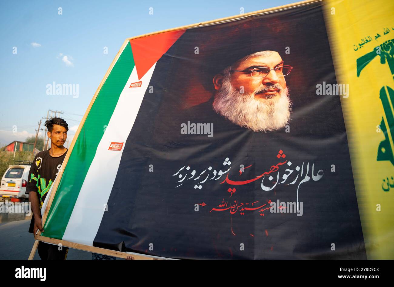A Kashmiri Shia Muslim man holds a poster depicting Sayyed Hassan ...