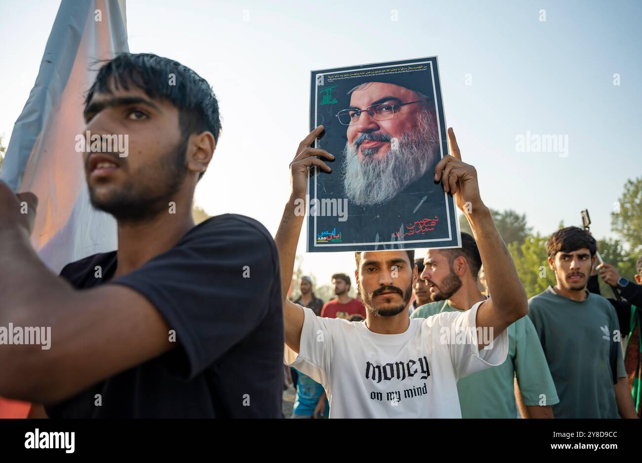A Kashmiri Shia Muslim man walks with a photograph of Sayyed Hassan ...