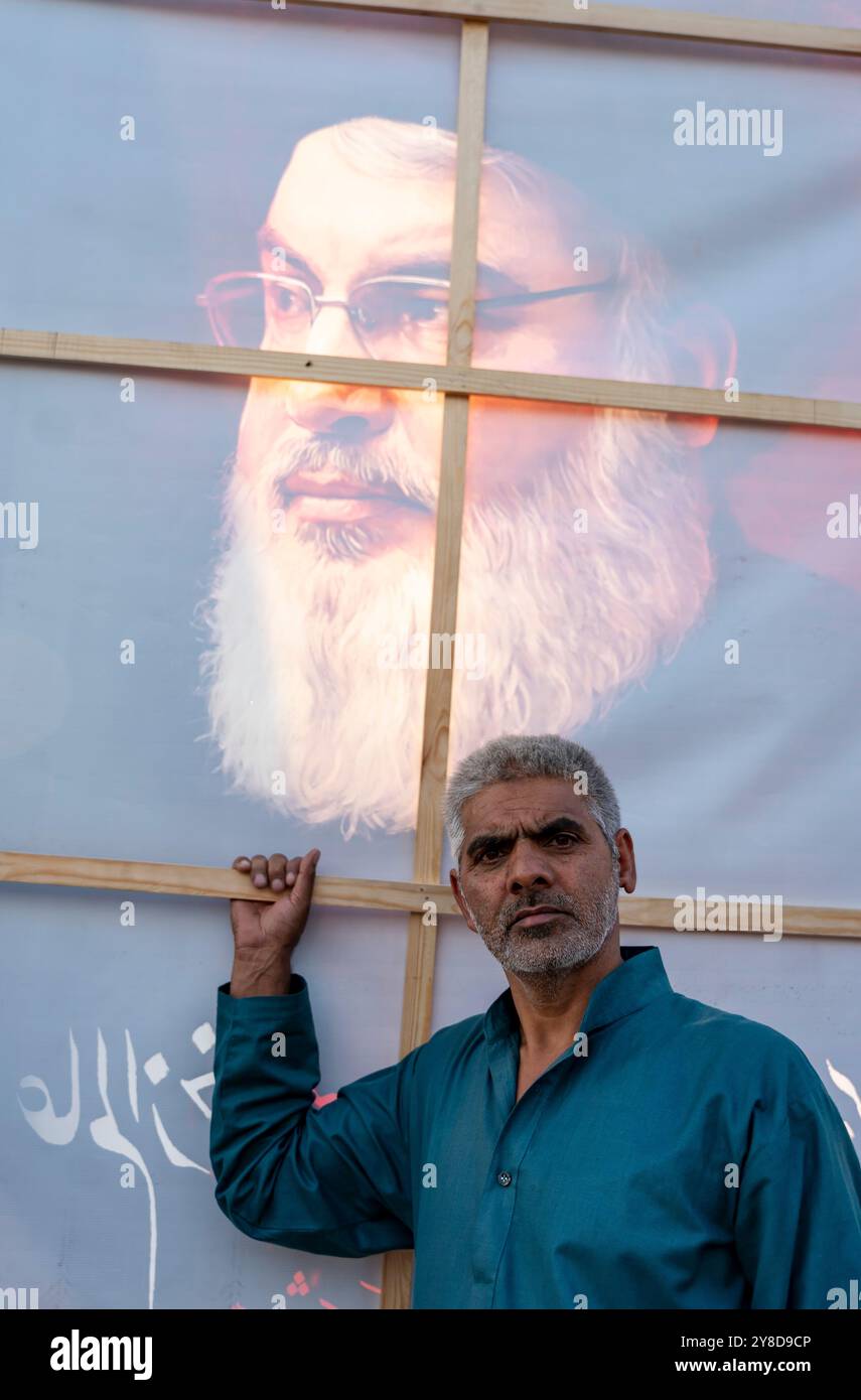A Kashmiri Shia Muslim man holds a banner depicting Sayyed Hassan ...