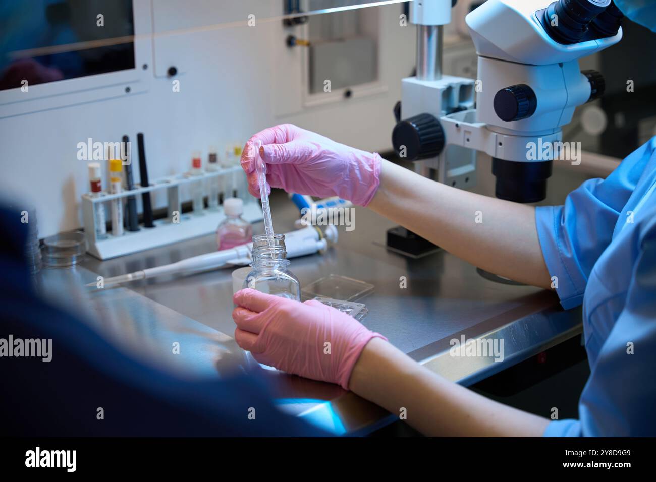 Embryologist handling lab samples under a microscope Stock Photo - Alamy