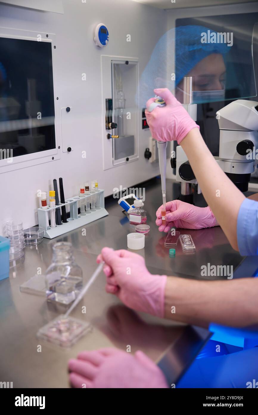 Male and Female embryologists performing lab task with coordinated ...