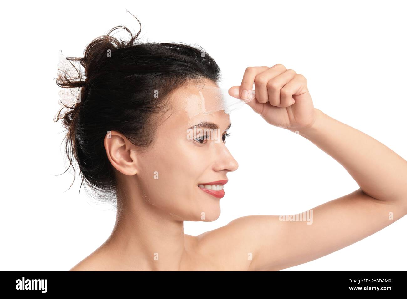 Smiling woman peeling off face mask on white background Stock Photo - Alamy